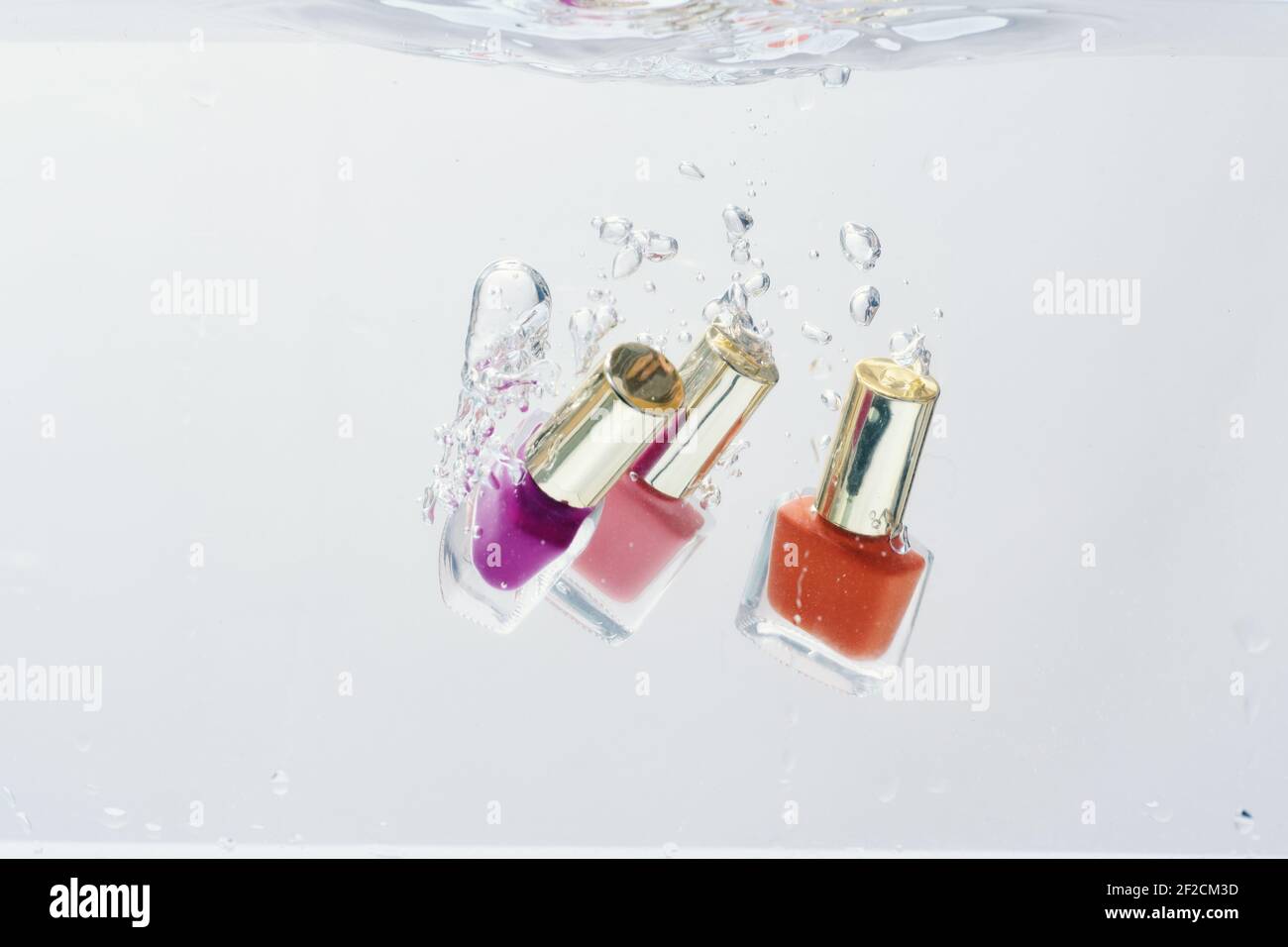 Beauty and care concept. Nail polish bottles under water with trail of ...