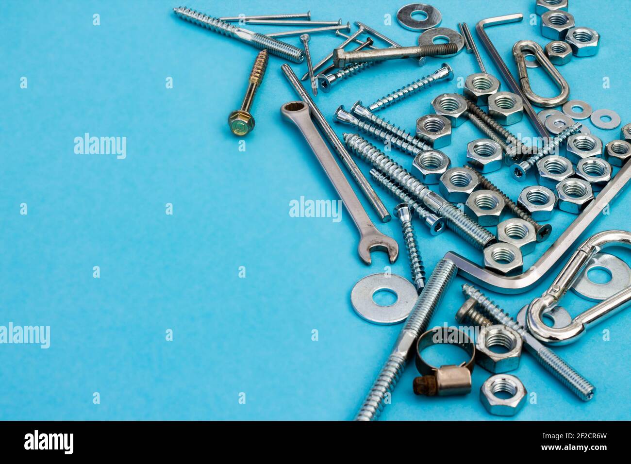 Bolts, nuts, wrenches and other construction tools on a blue background ...