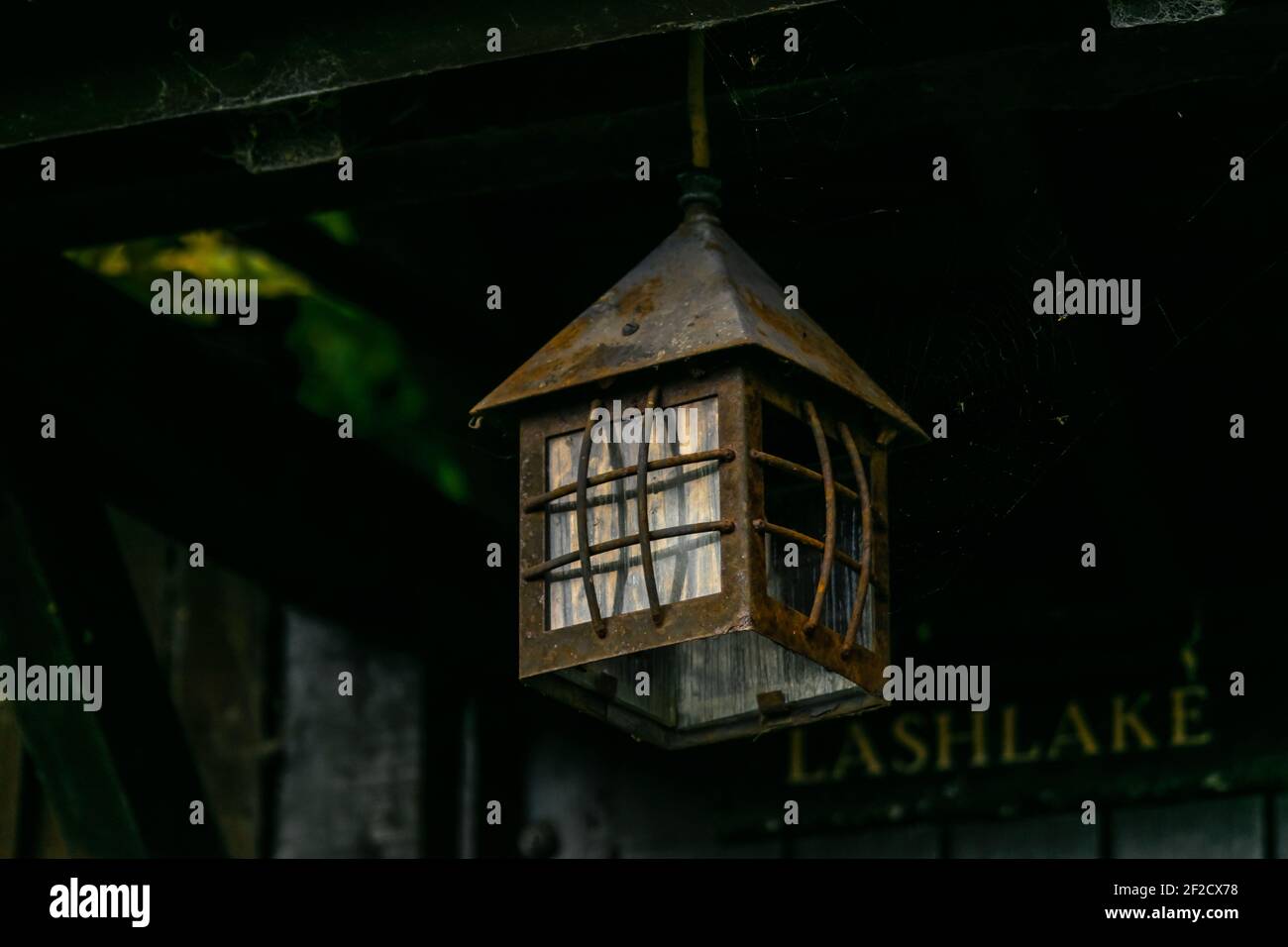 Single vintage lantern hanging over the door to old english cottage ...