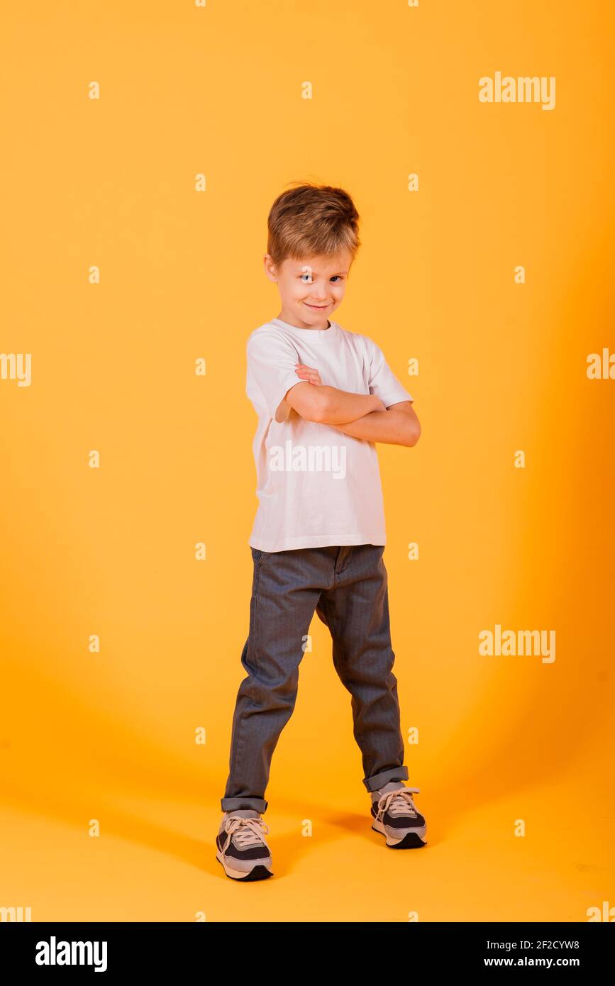 Portrait of happy little boy over yellow background in studio Stock ...