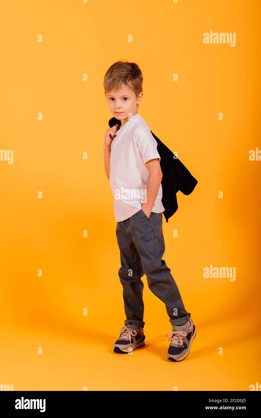 Portrait of happy little boy over yellow background in studio Stock ...