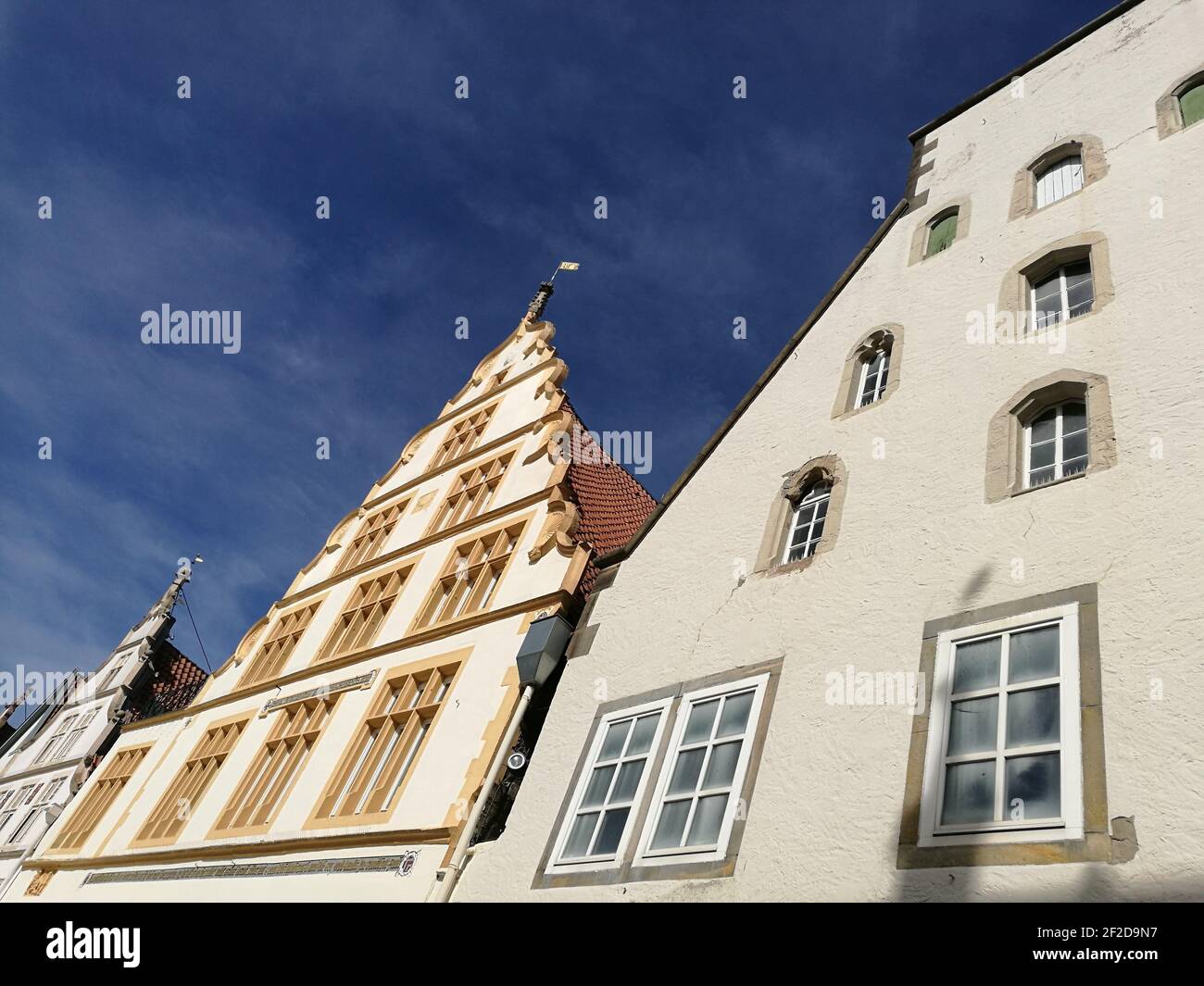 A low-angle shot of the half-timbered facades of two buildings against ...