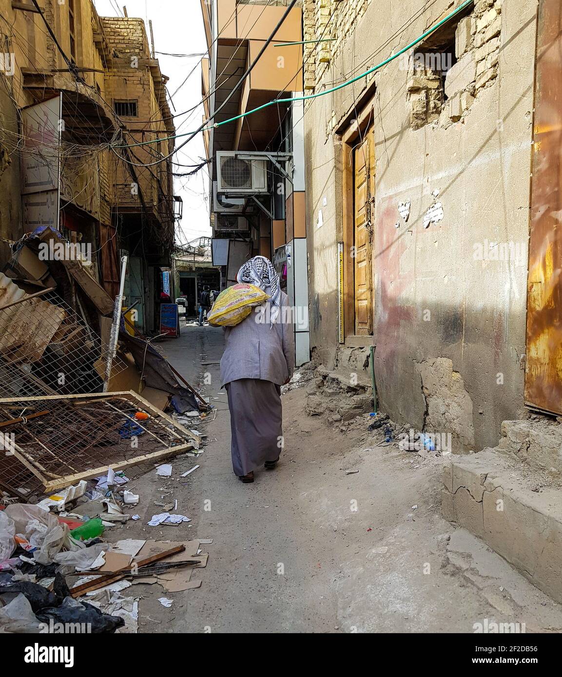 Person Carrying a Sack in a Dirty Alleyway Stock Photo - Alamy