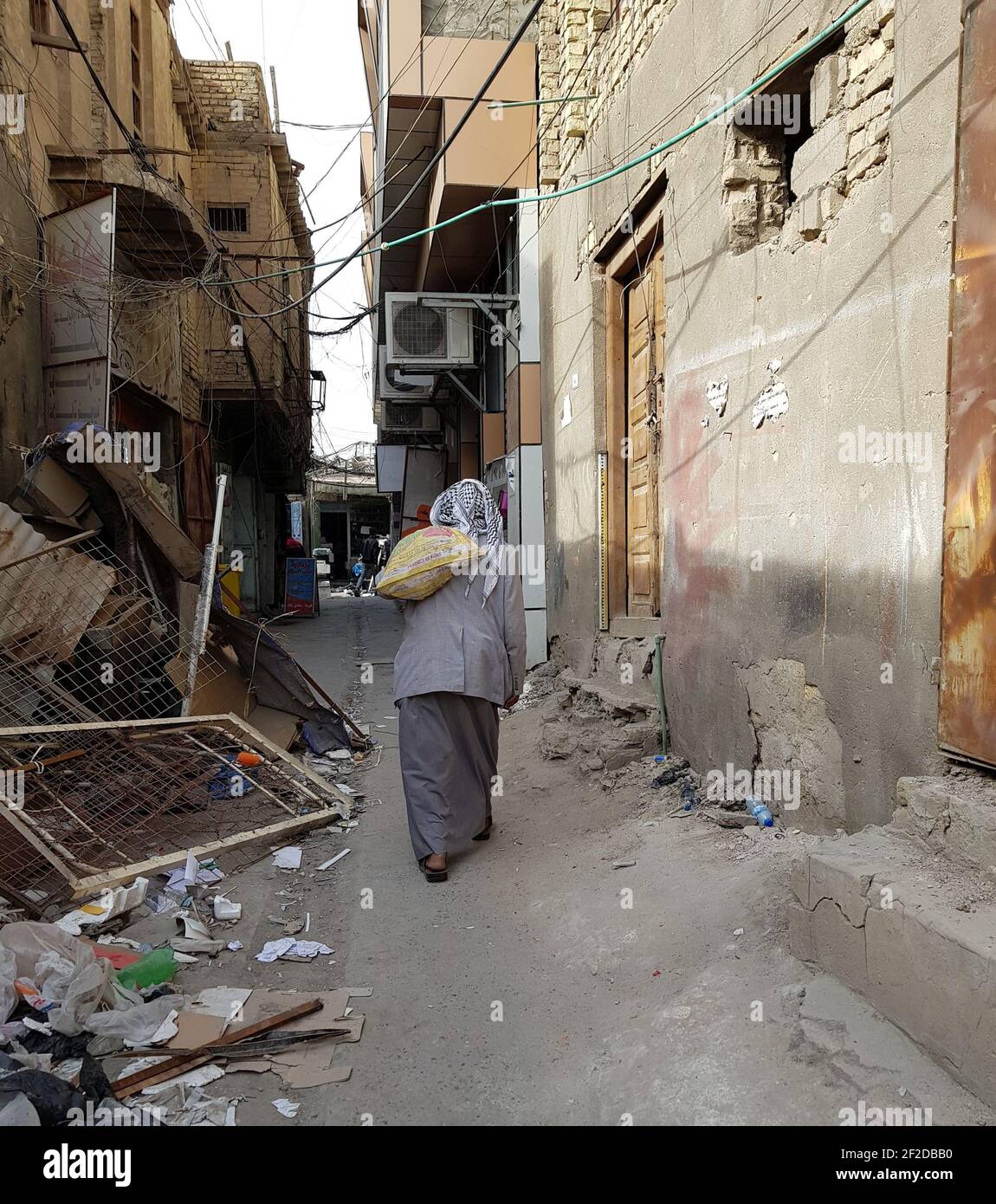 Person Carrying a Sack in a Dirty Alleyway Stock Photo - Alamy