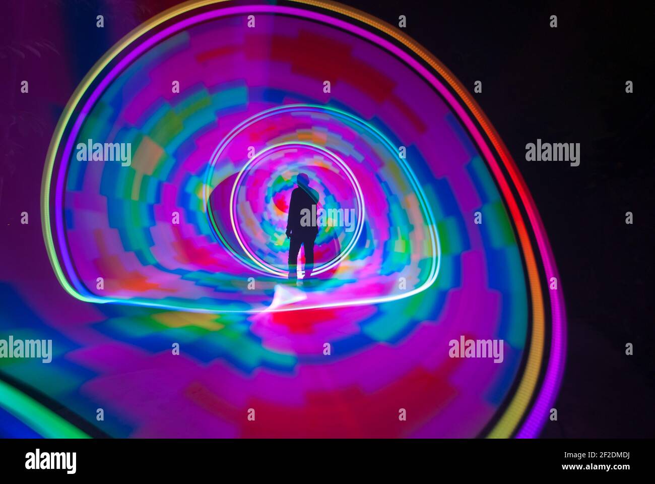 One person standing alone against beautiful color circle LED light ...