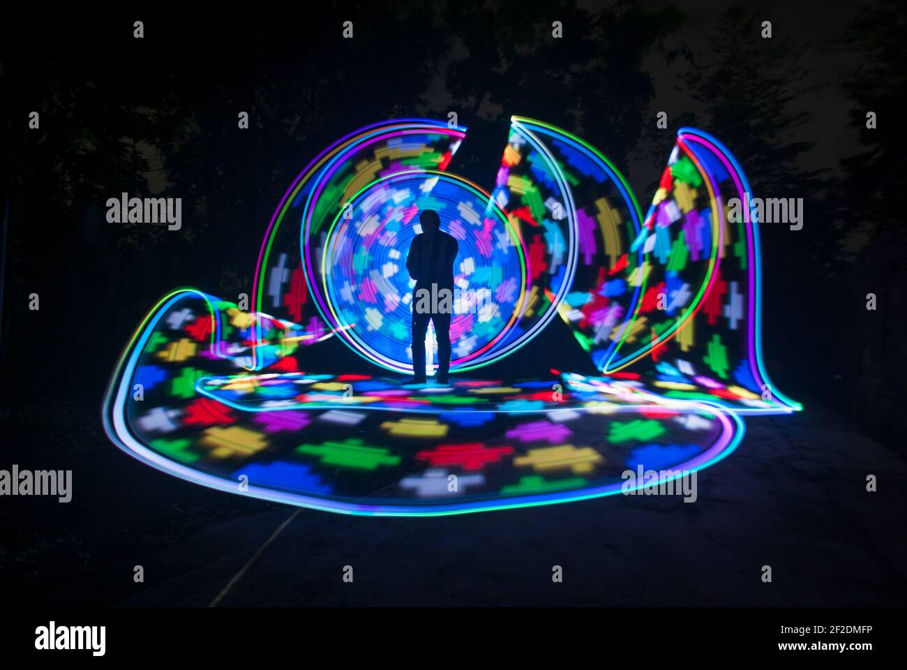 One person standing alone against beautiful color circle LED light ...