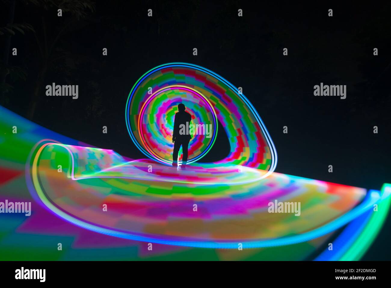 One person standing alone against beautiful color circle LED light ...