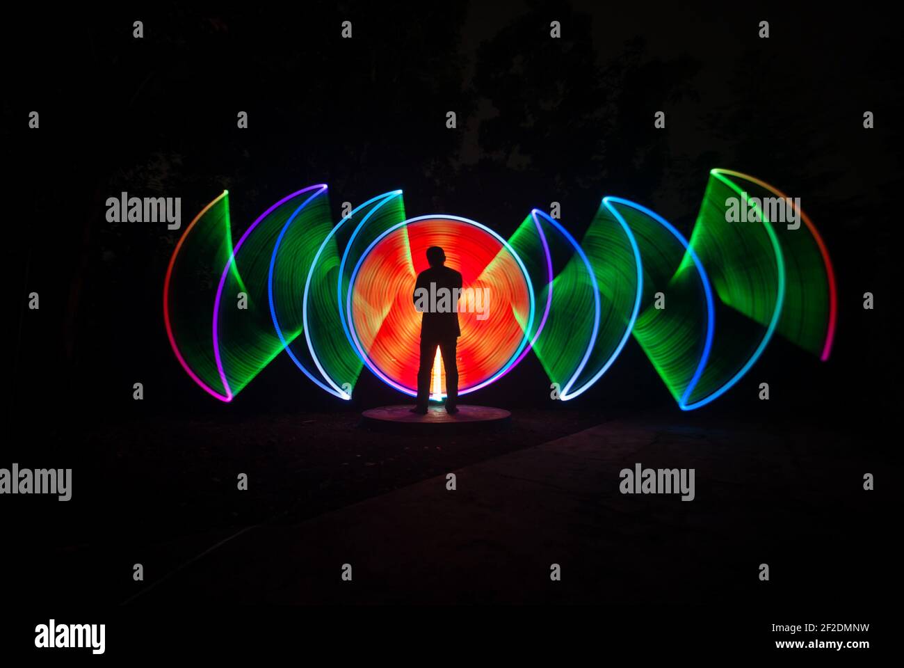 One person standing alone against beautiful color circle LED light ...