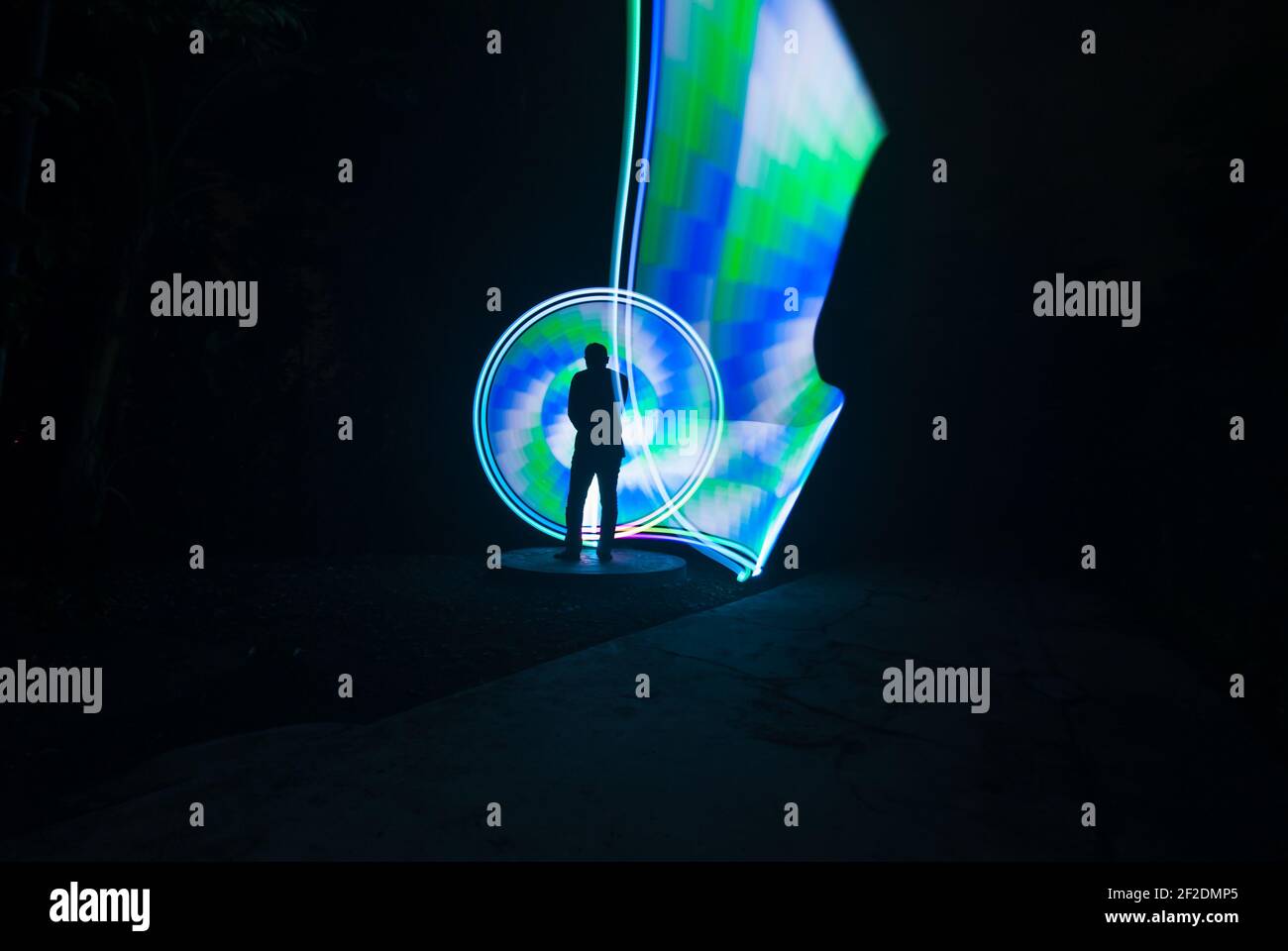 One person standing alone against beautiful color circle LED light ...