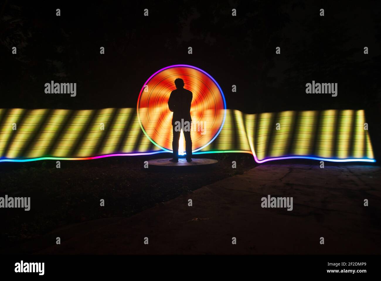 One person standing alone against beautiful color circle LED light ...
