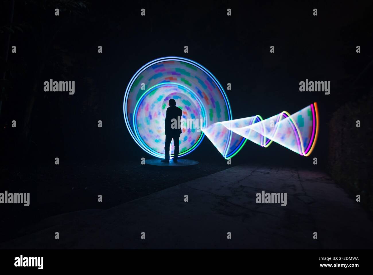 One person standing alone against beautiful color circle LED light ...