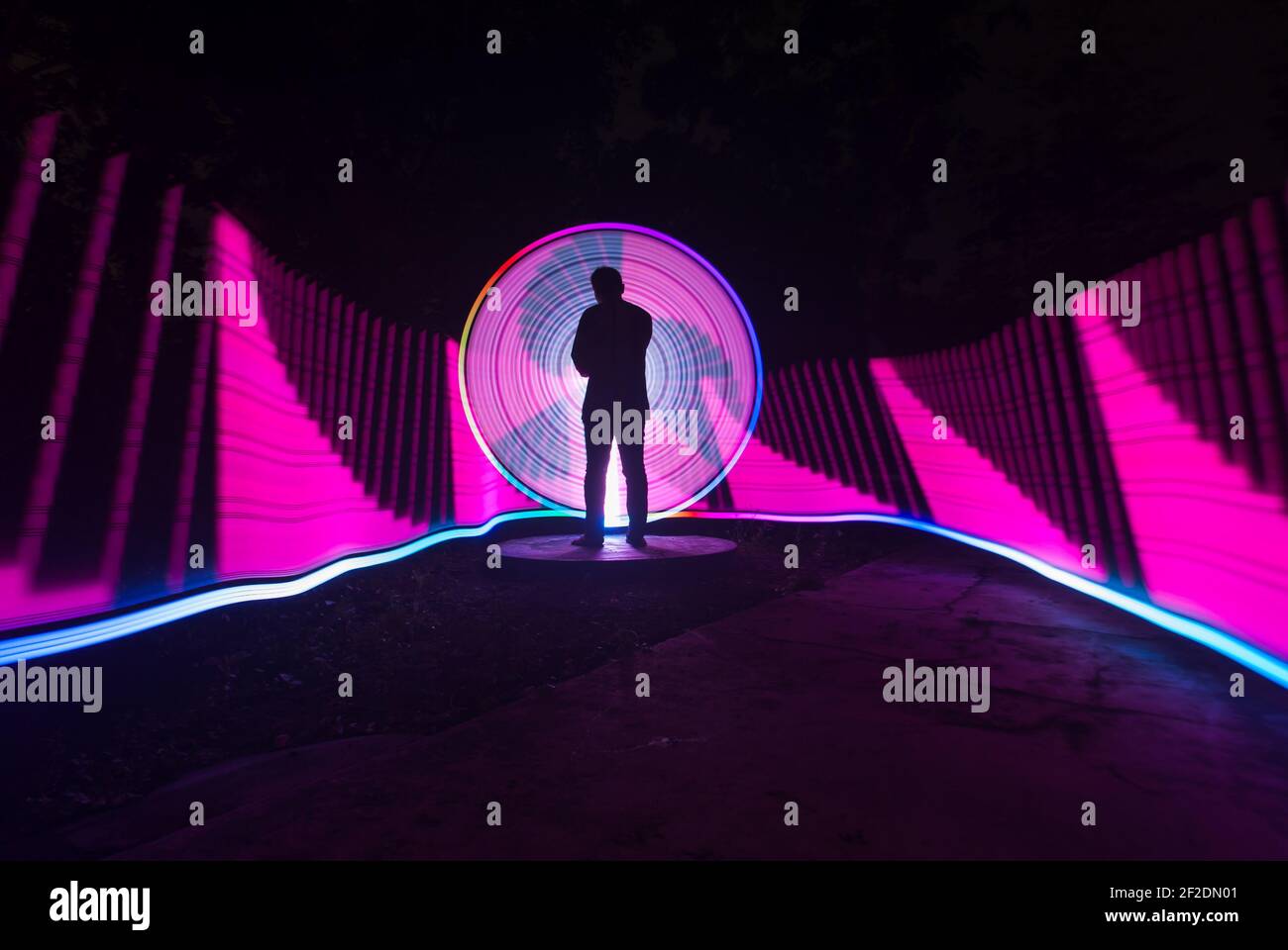 One person standing alone against beautiful color circle LED light ...