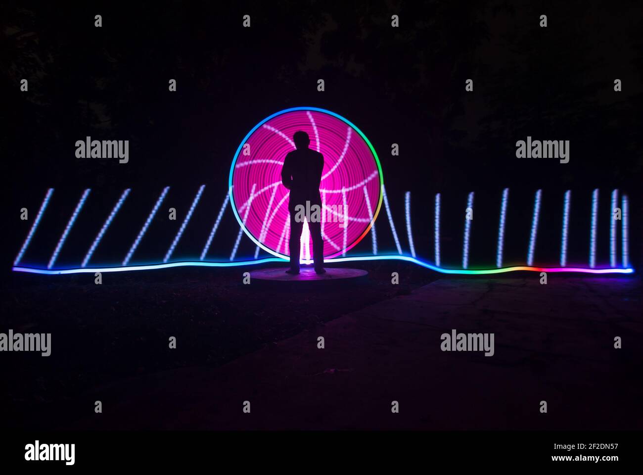 One person standing alone against beautiful color circle LED light ...