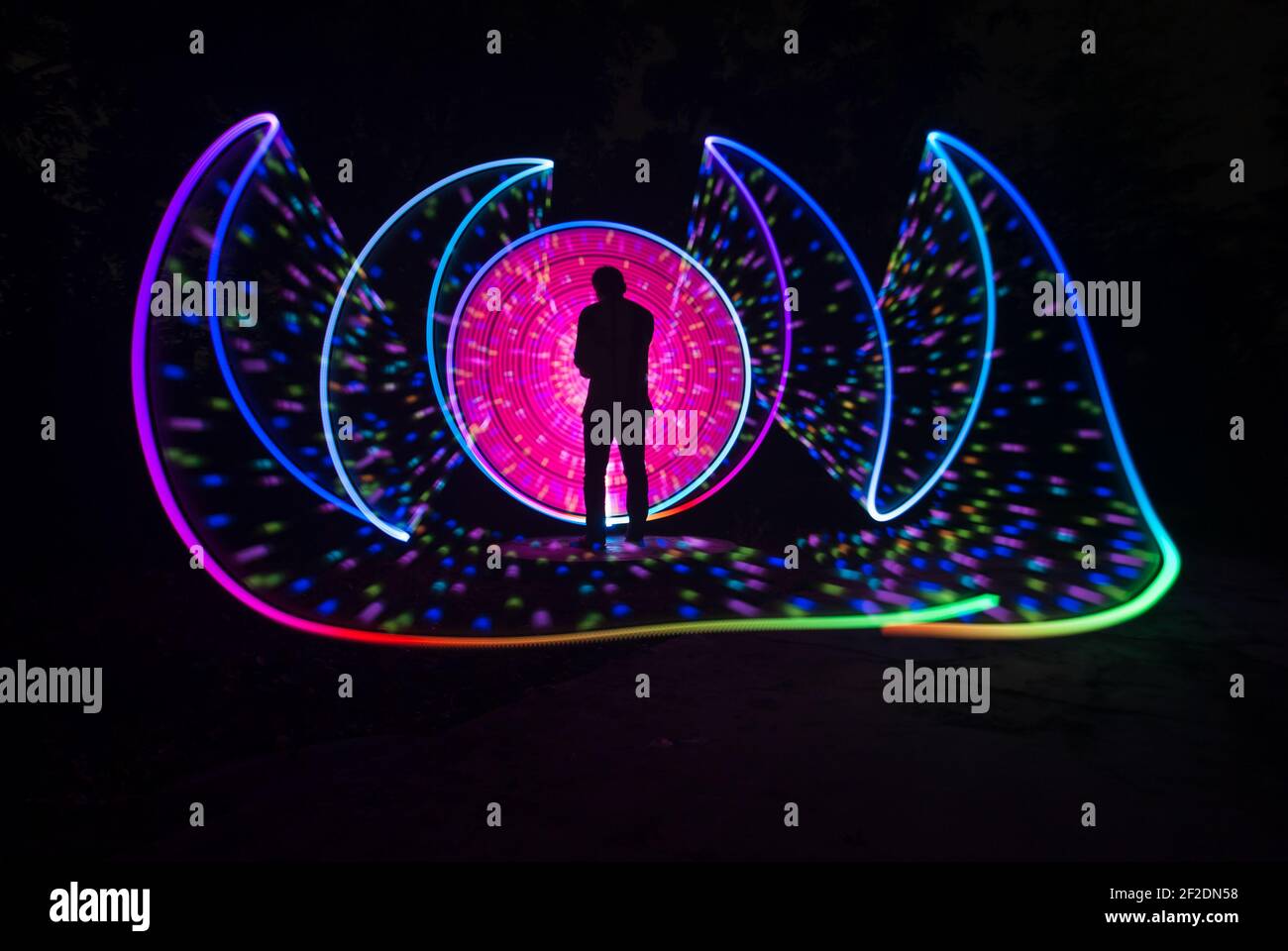 One person standing alone against beautiful color circle LED light ...