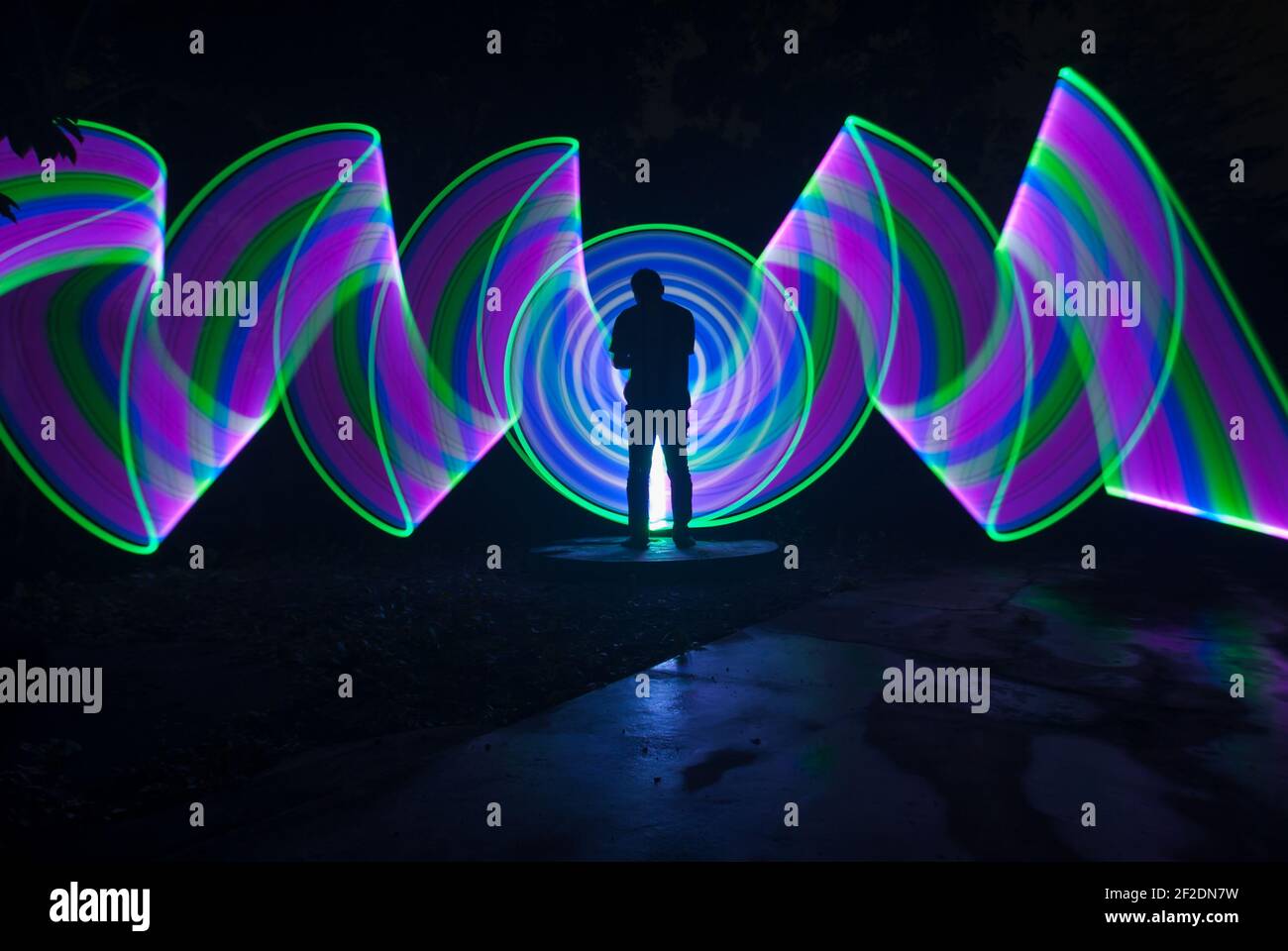 One person standing alone against beautiful color circle LED light ...