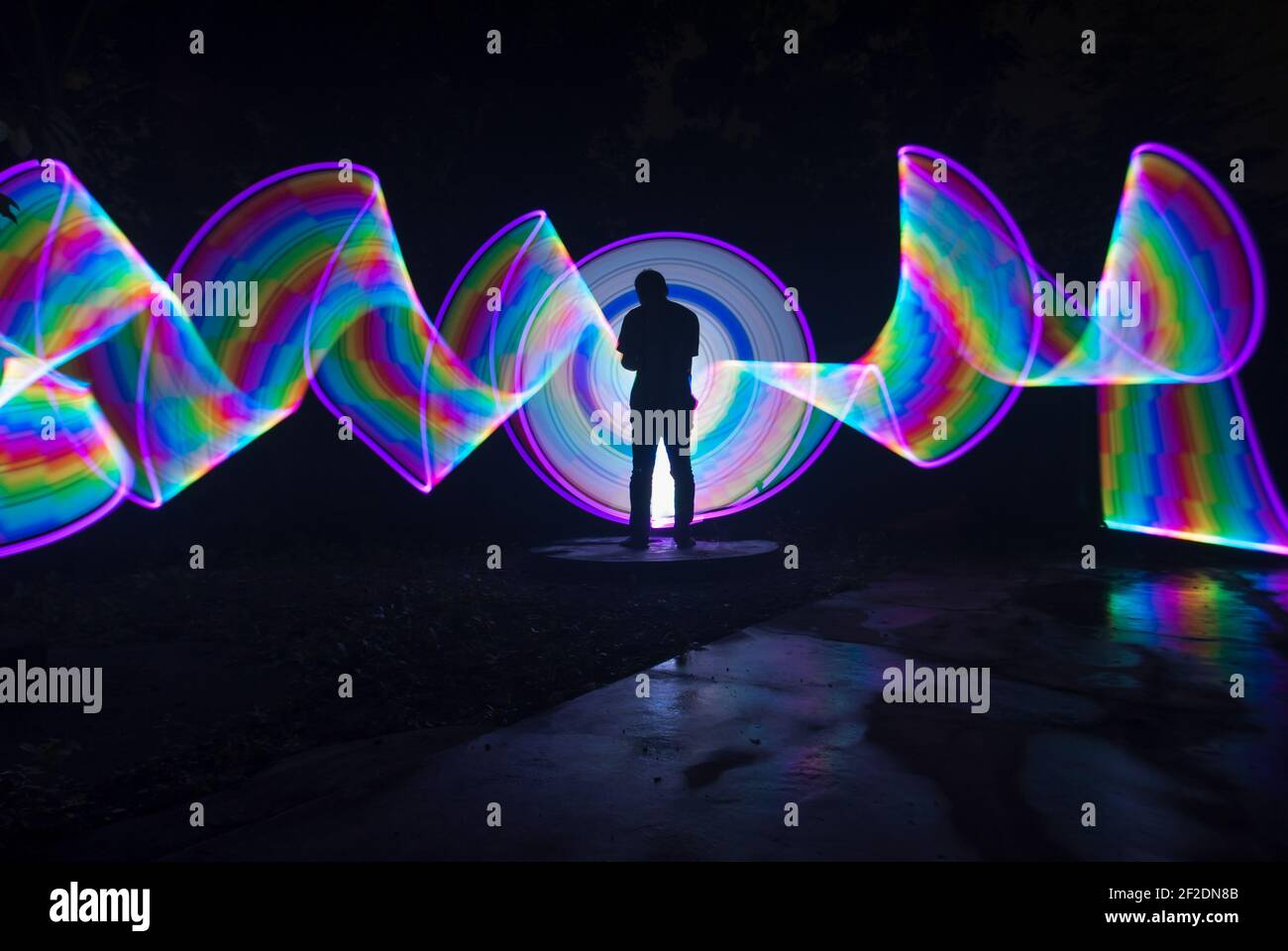 One person standing alone against beautiful color circle LED light ...