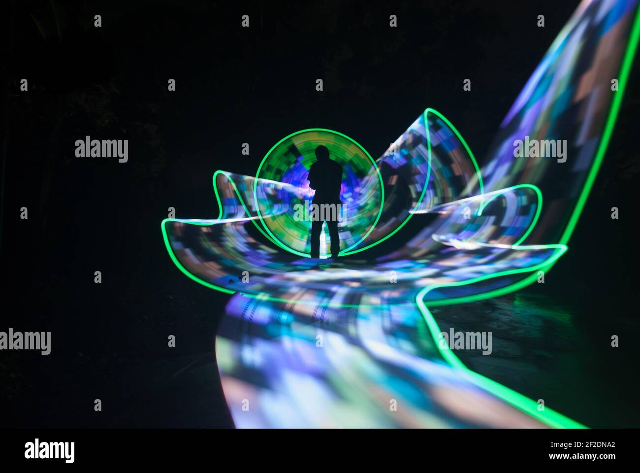 One person standing alone against beautiful color circle LED light ...