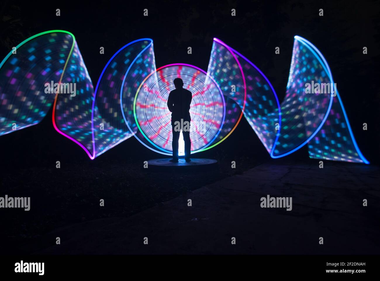 One person standing alone against beautiful color circle LED light ...