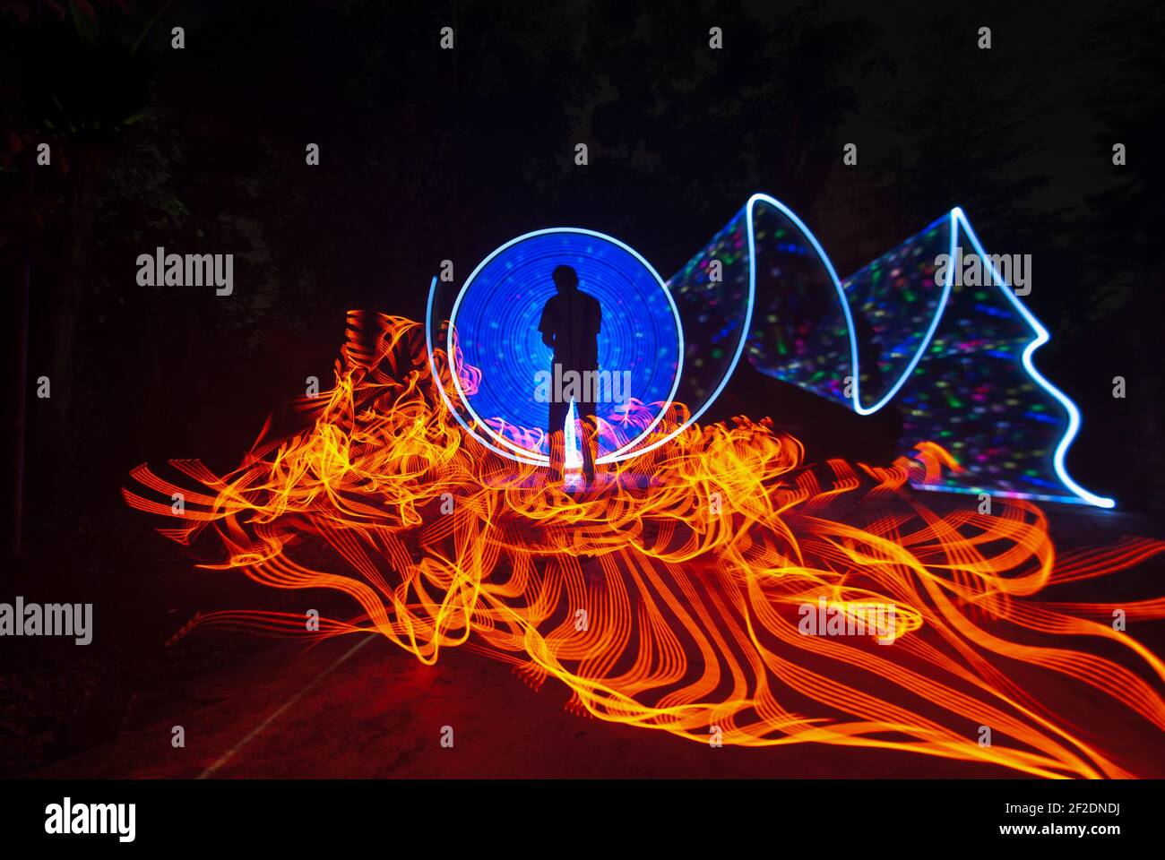 One person standing alone against beautiful color circle LED light ...