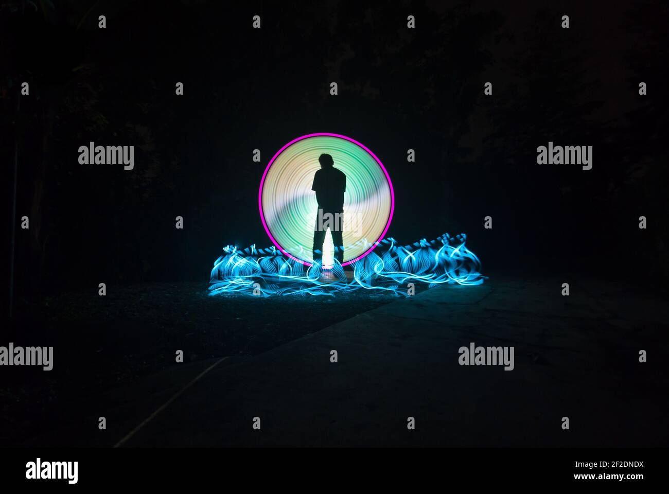 One person standing alone against beautiful color circle LED light ...