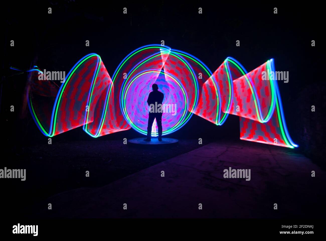 One person standing alone against beautiful color circle LED light ...