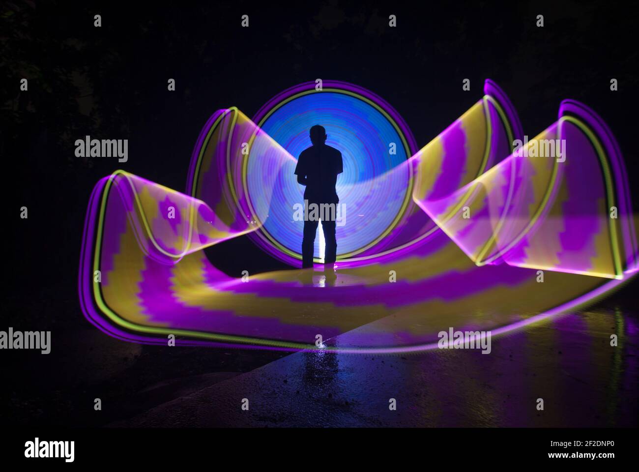One person standing alone against beautiful color circle LED light ...