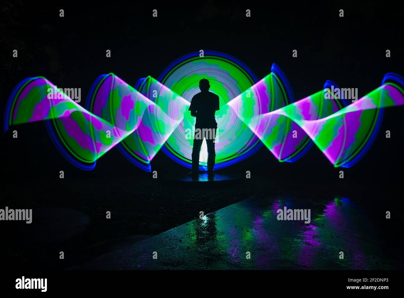 One person standing alone against beautiful color circle LED light ...