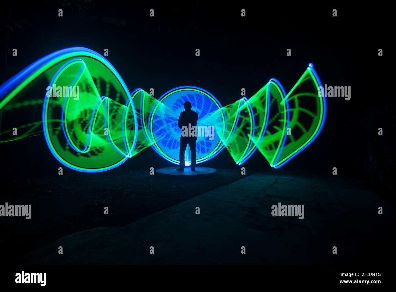 One person standing alone against beautiful color circle LED light ...