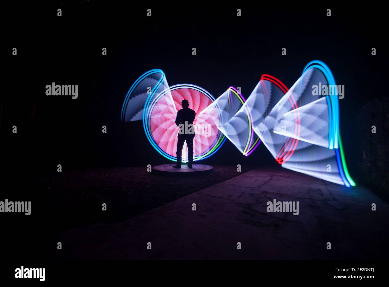 One person standing alone against beautiful color circle LED light ...