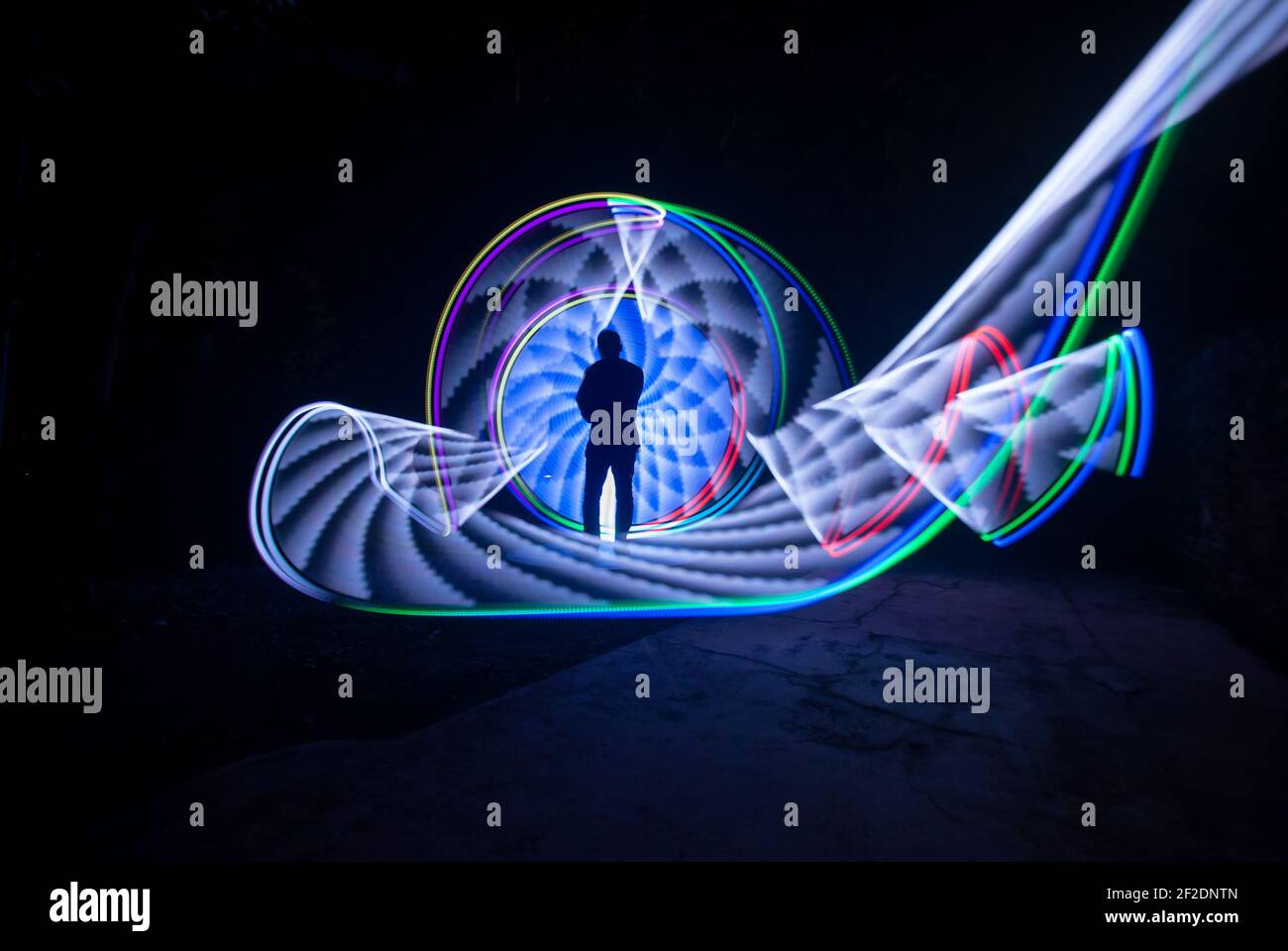 One person standing alone against beautiful color circle LED light ...