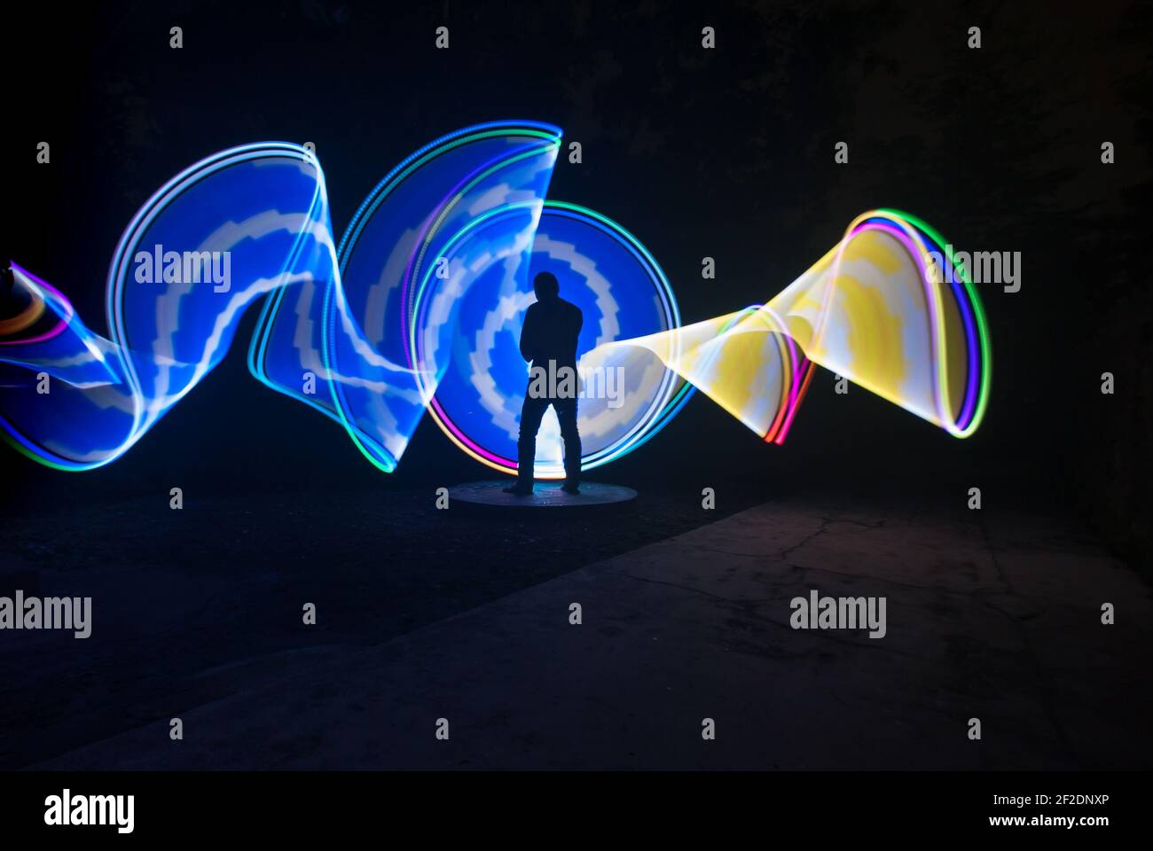 One person standing alone against beautiful color circle LED light ...