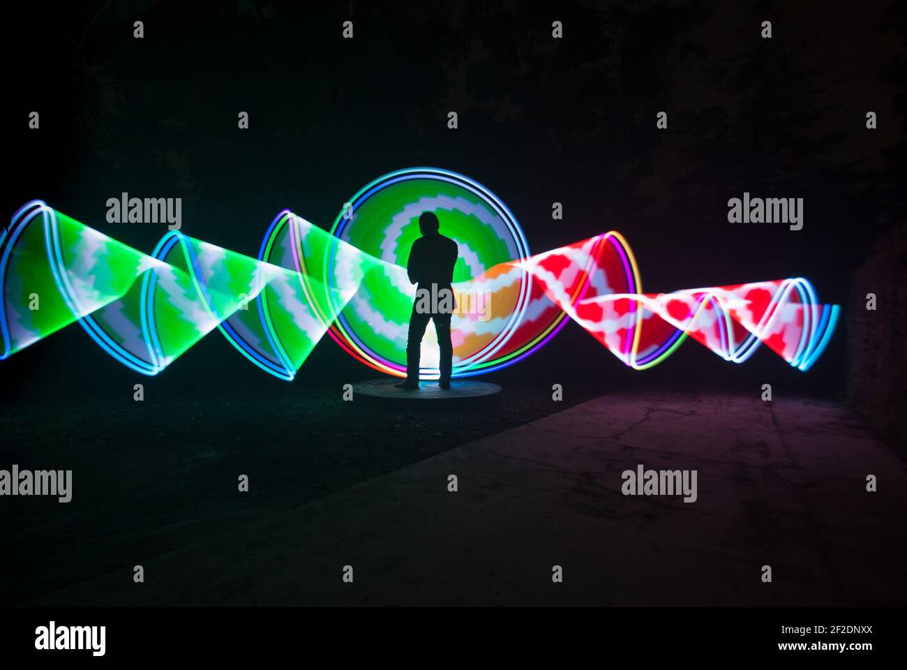 One person standing alone against beautiful color circle LED light ...