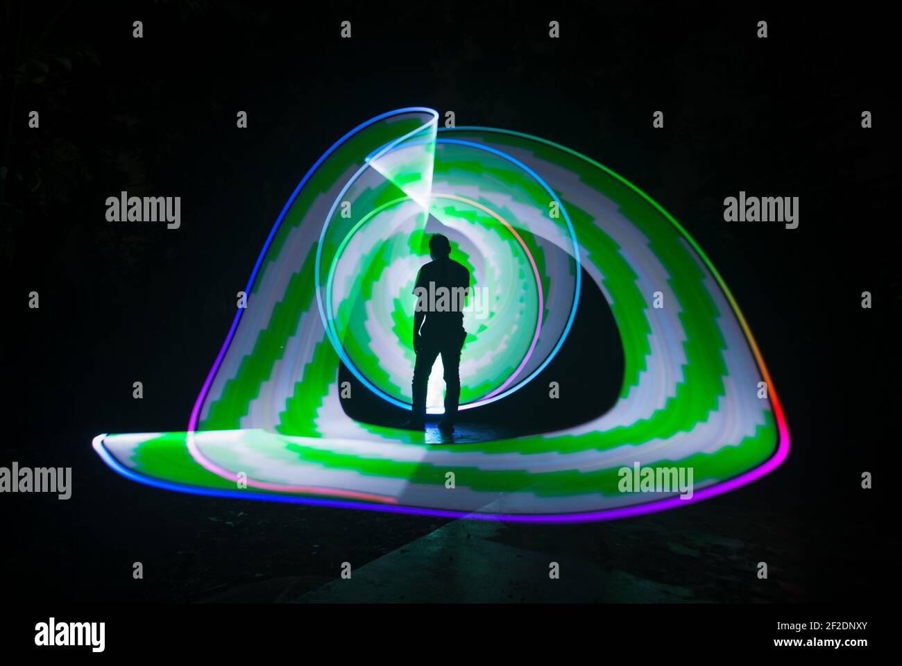 One person standing alone against beautiful color circle LED light ...