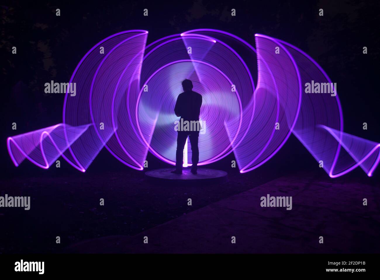 One person standing alone against beautiful color circle LED light ...