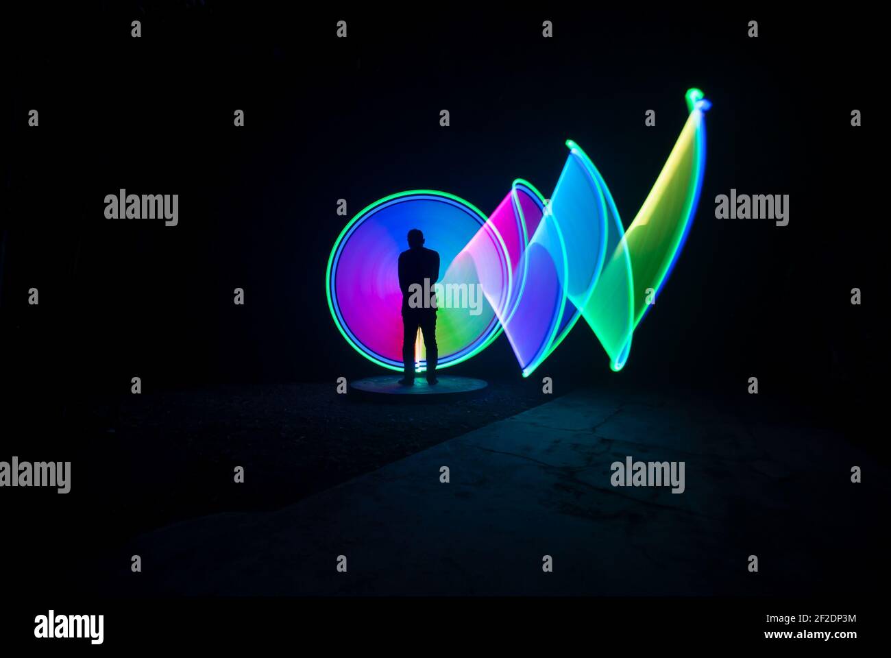 One person standing alone against beautiful color circle LED light ...