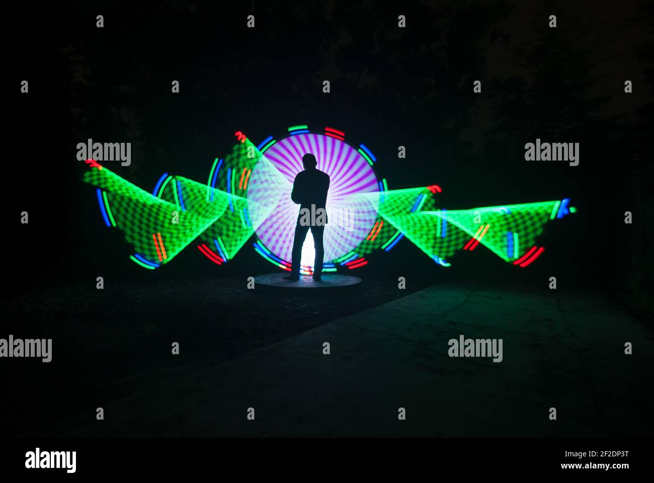 One person standing alone against beautiful color circle LED light ...