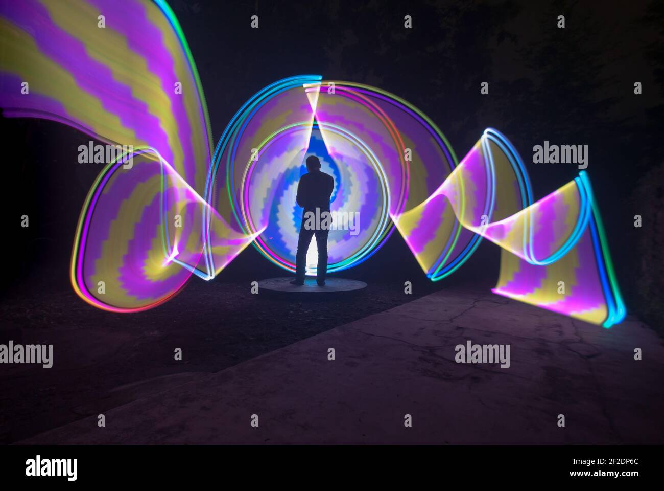 One person standing alone against beautiful color circle LED light ...