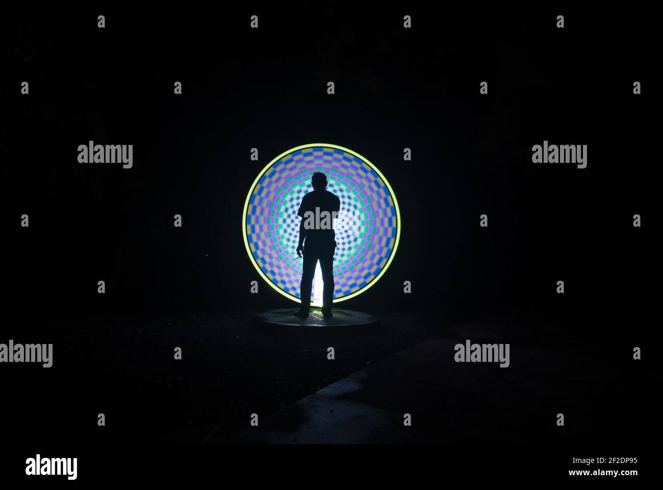 One person standing alone against beautiful color circle LED light ...