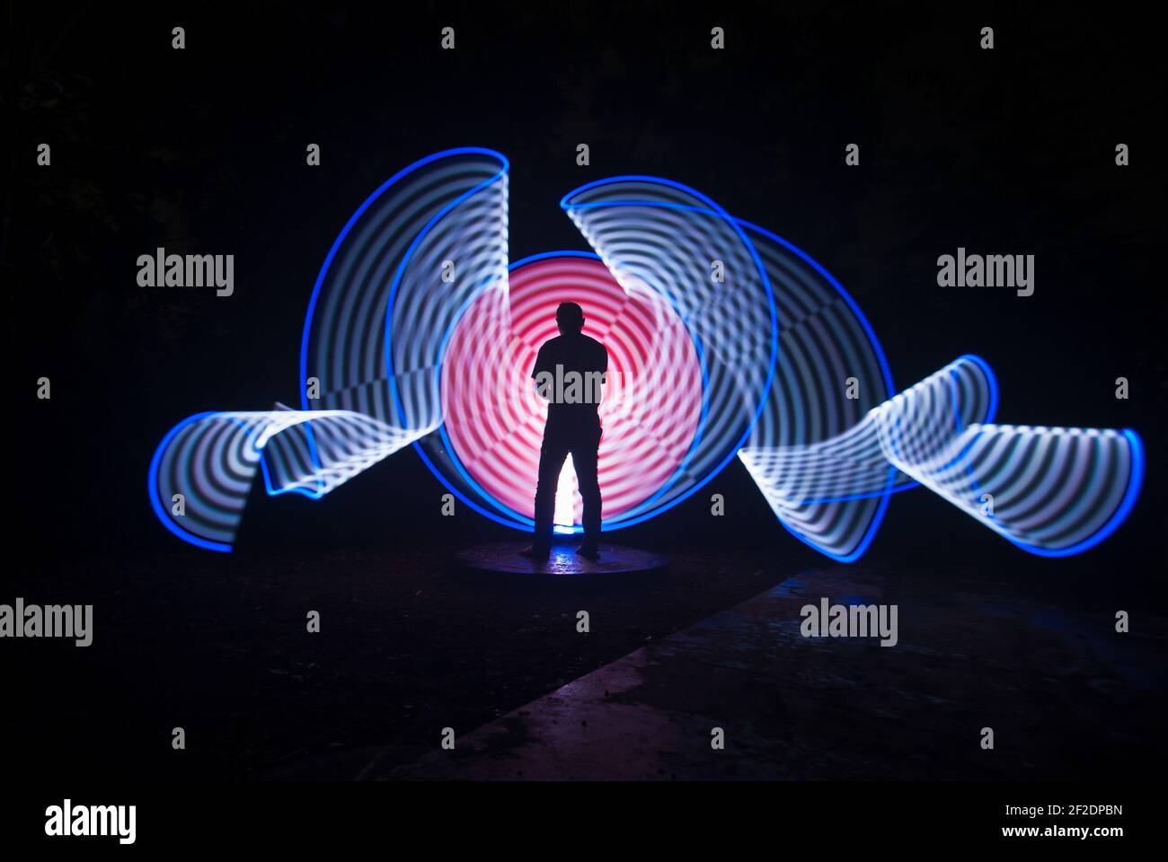 One person standing alone against beautiful color circle LED light ...