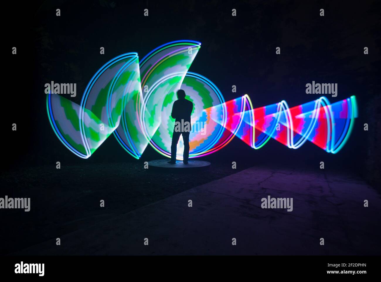 One person standing alone against beautiful color circle LED light ...