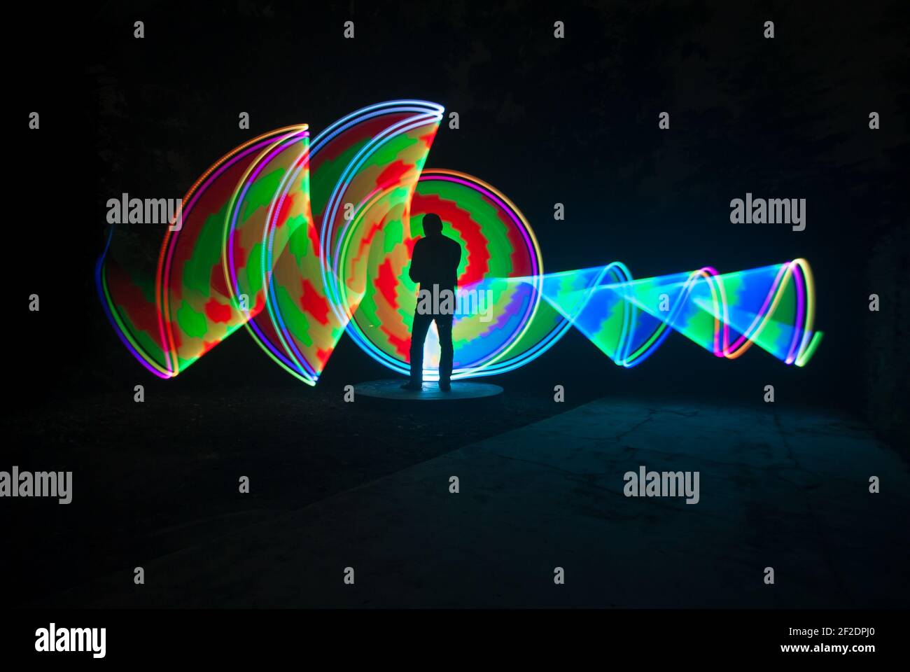 One person standing alone against beautiful color circle LED light ...