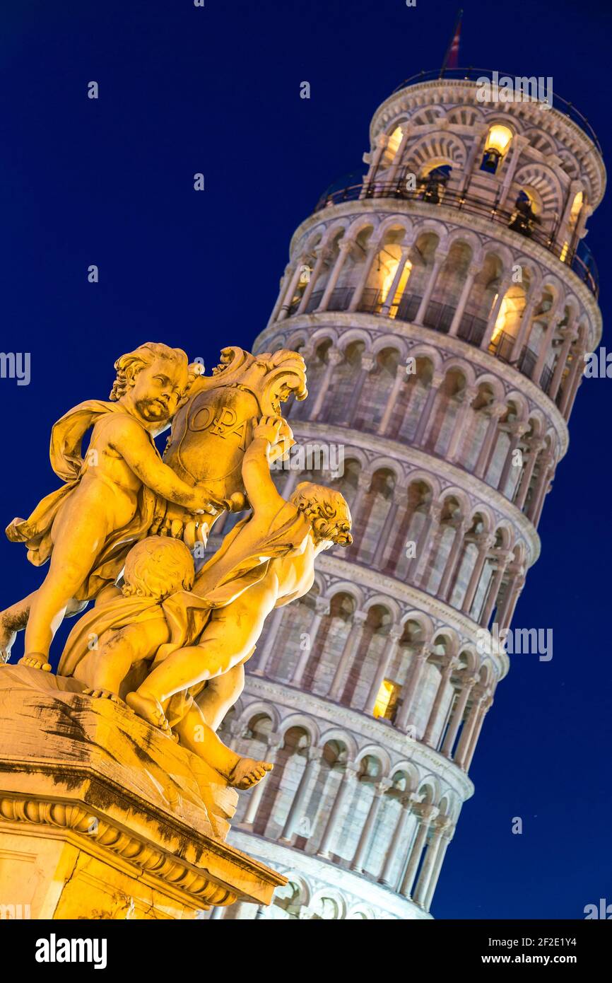 Leaning tower in Pisa with statue of angels in a summer evening in ...