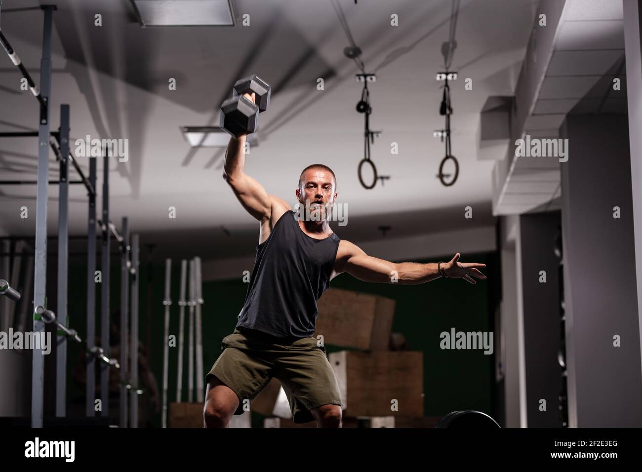 Muscular athlete lifting very heavy weights. Man working out indoors ...