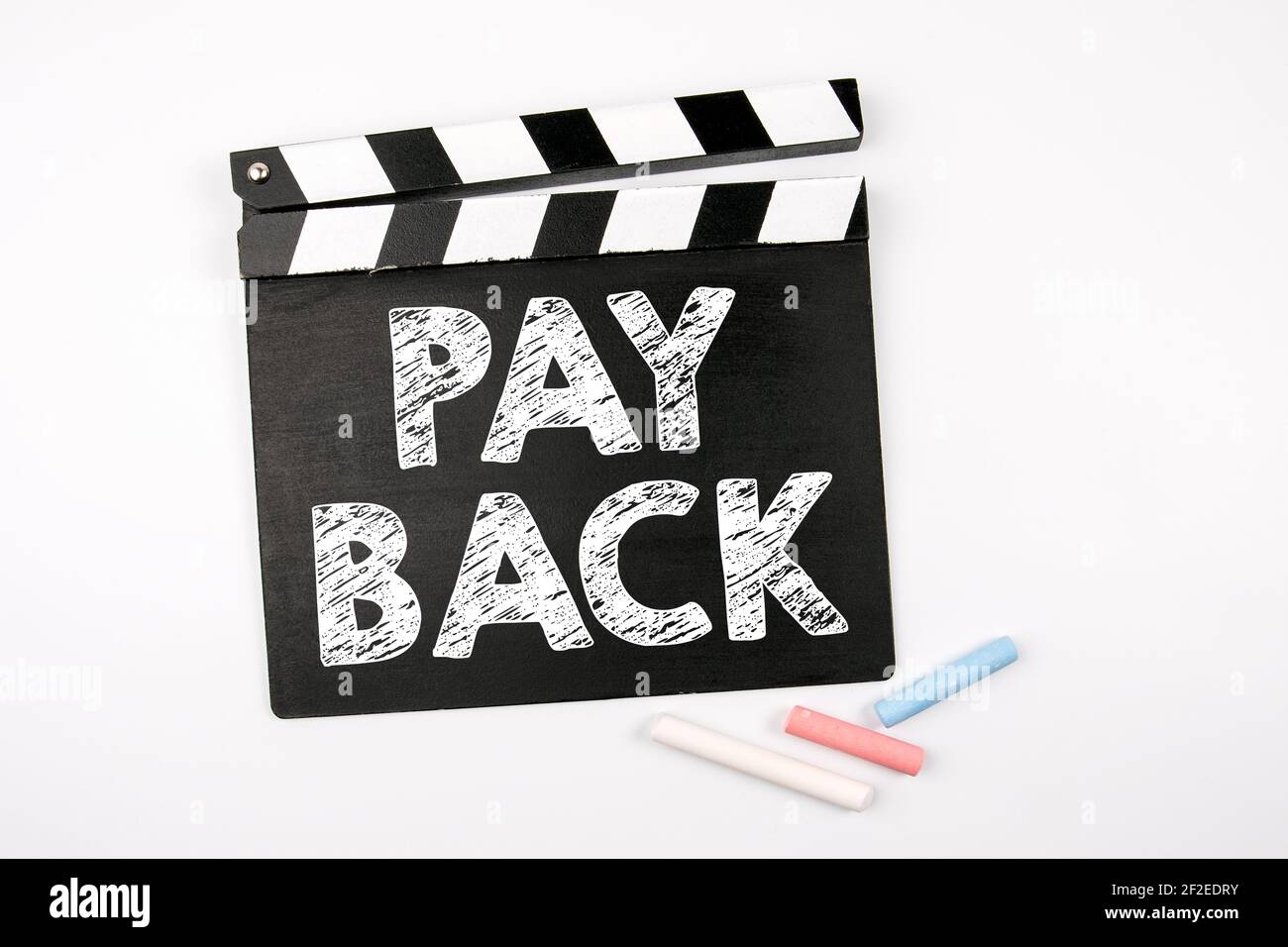 PAY BACK concept. Black movie clapper with chalk pieces on a white ...