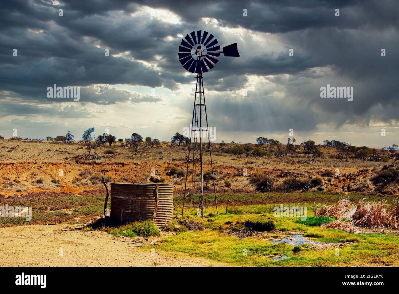 Rain? Windmill and tank with dry farmland Stock Photo - Alamy