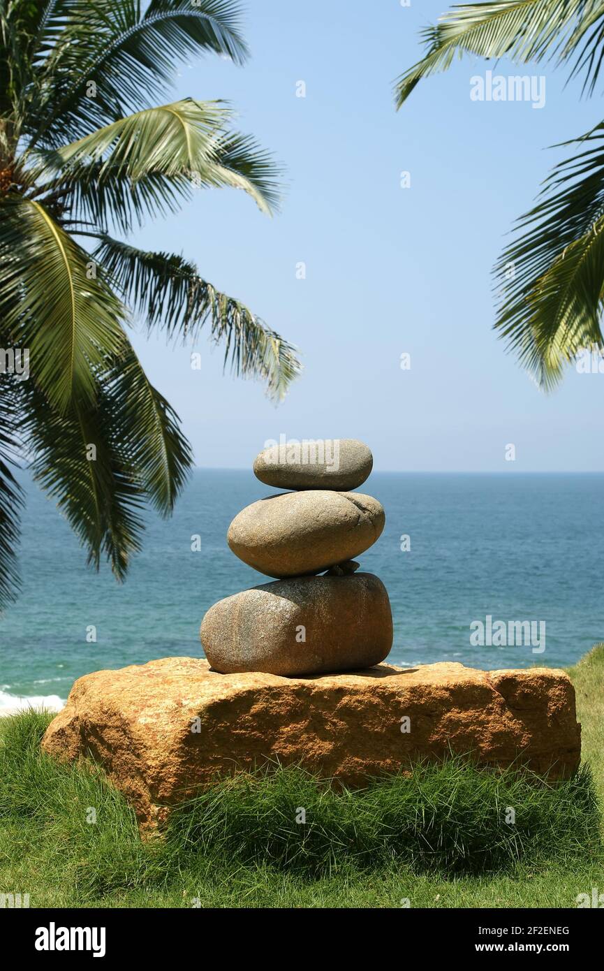 Pile of pebble Stones against the background of palm trees and the sea ...