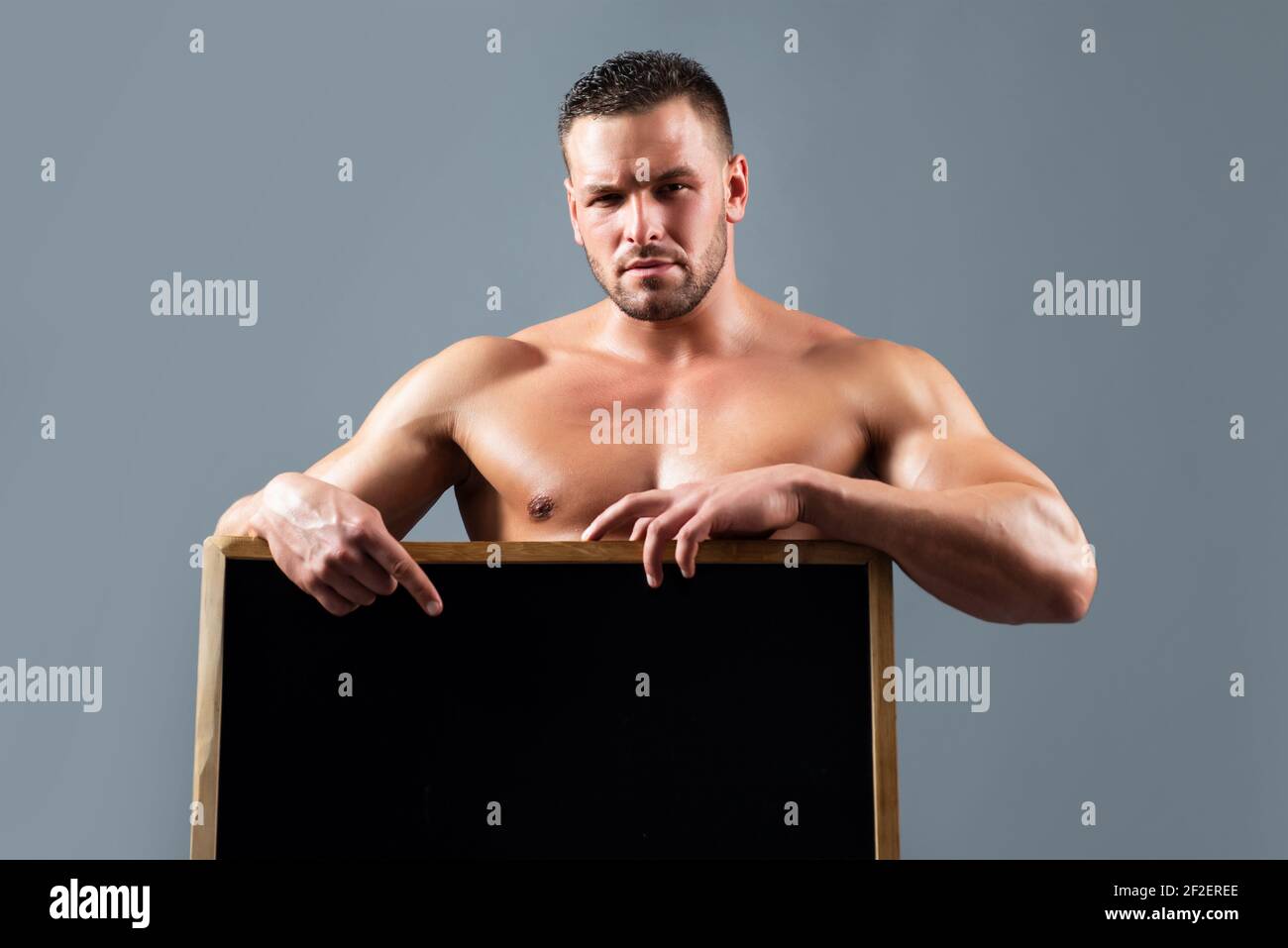 Advertising concept. Fitness man with sign board. Strong bodybuilder ...