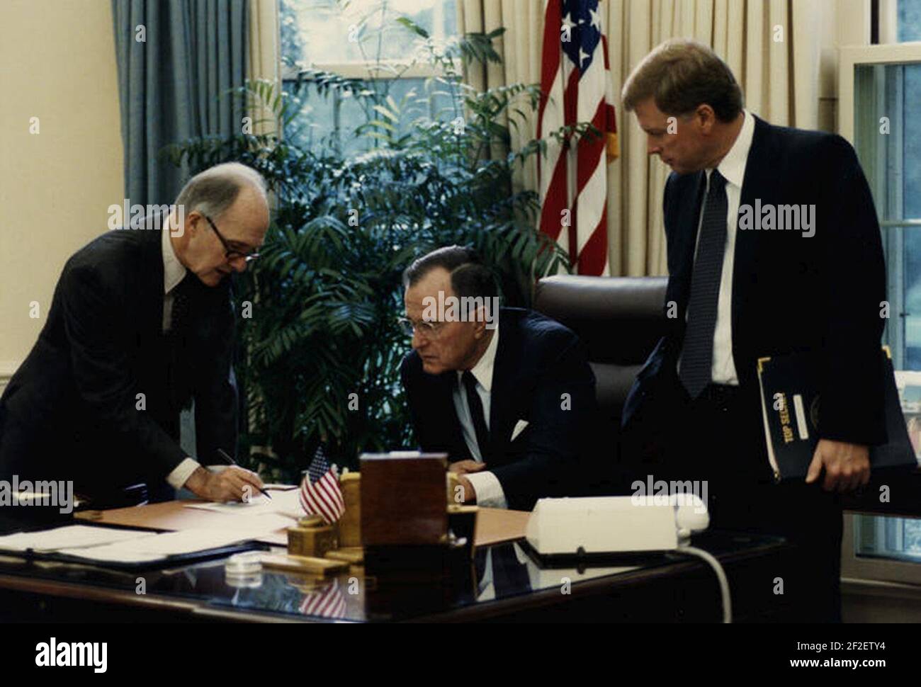 President George H. W. Bush reads a document as General Brent Scowcroft ...