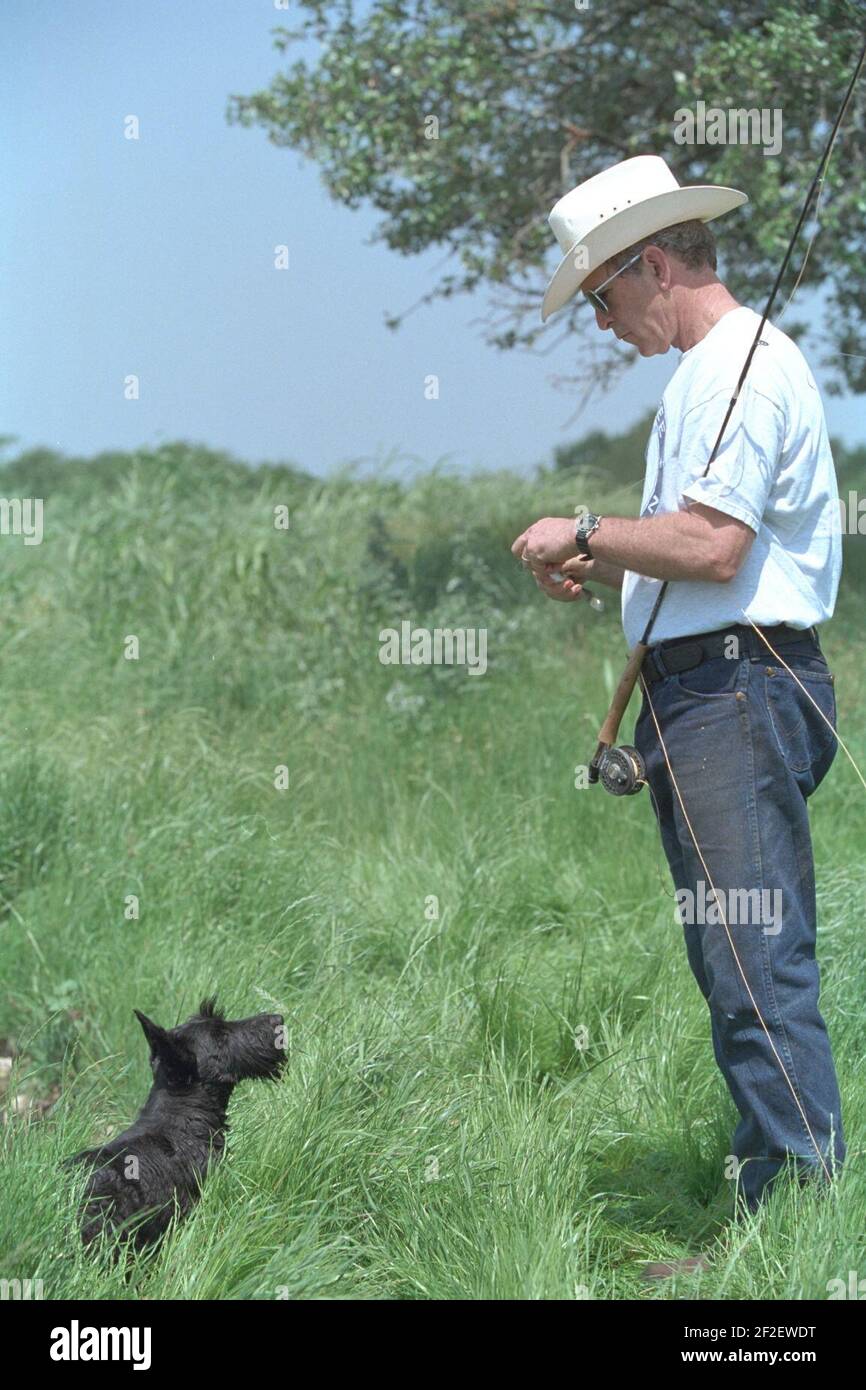 President George W. Bush Carries a Fishing Pole as he Walks to the Pond ...