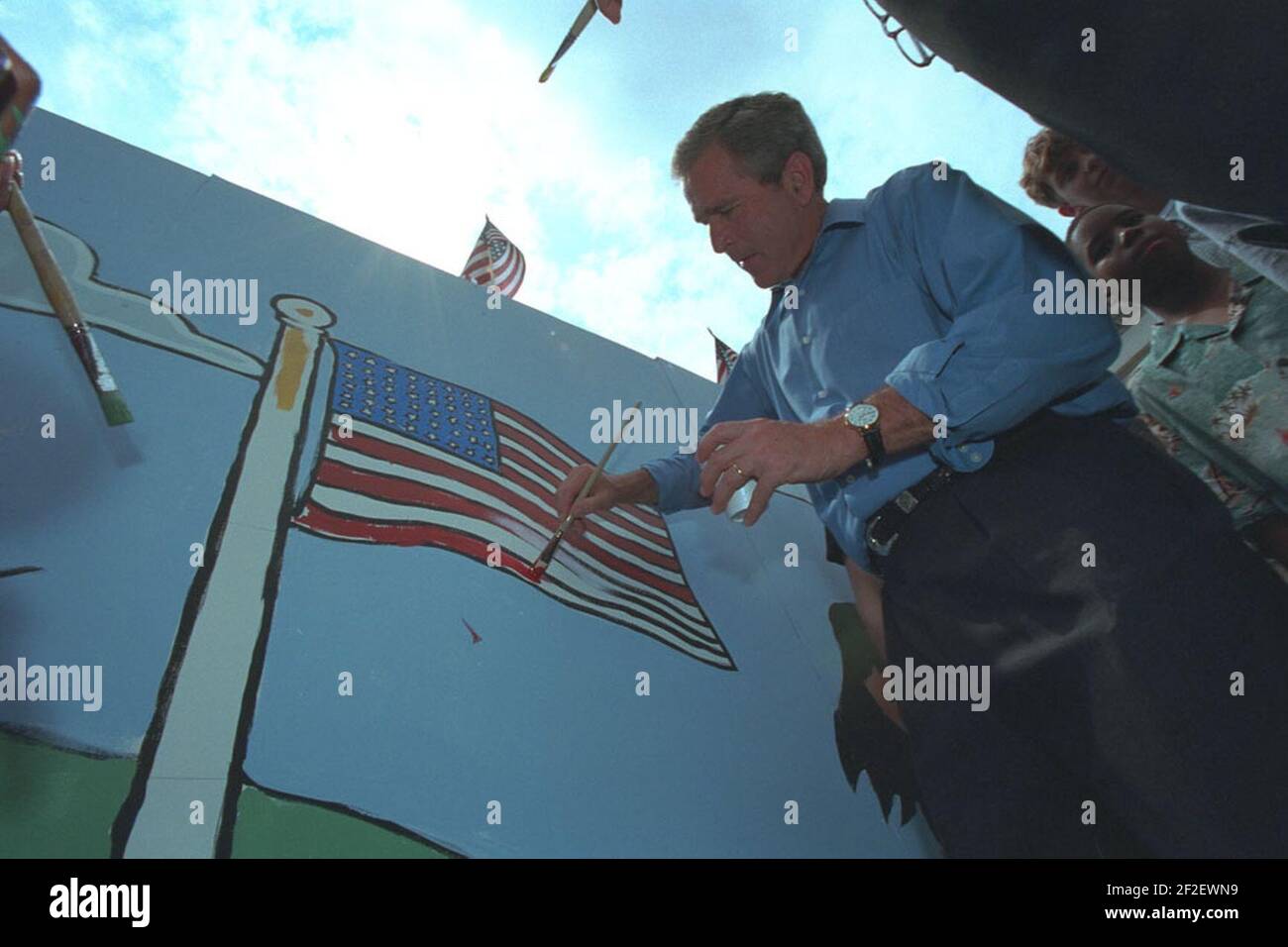 President George W. Bush Paints a Red Stripe on an American Flag Mural ...